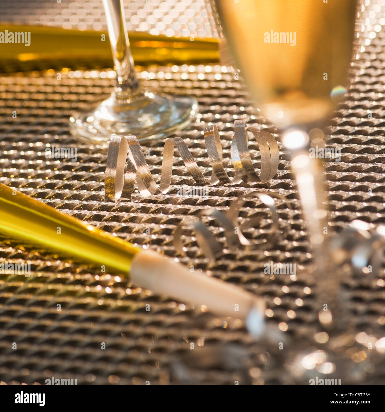 Flutes with champagne and party horn blowers Stock Photo - Alamy