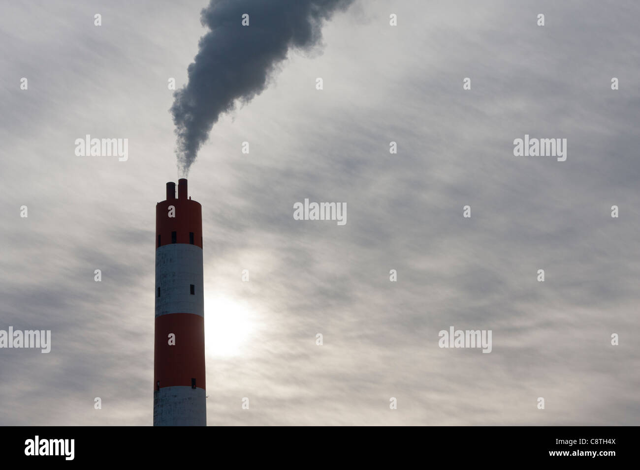 A chimney belching out smoke and steam in front of a dawn sky. Kanagawa ...