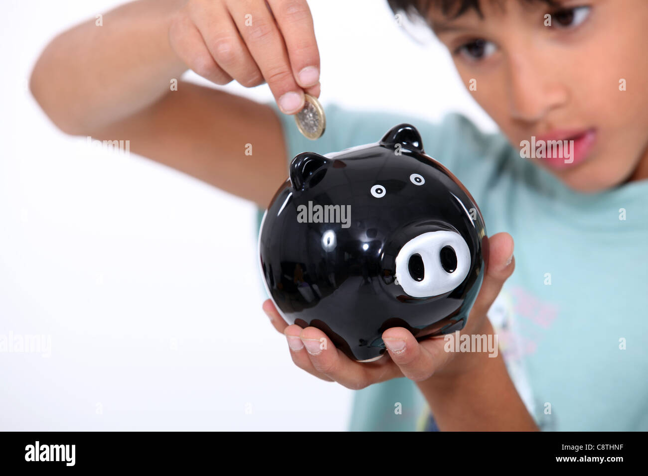 boy putting a coin into a money box Stock Photo - Alamy
