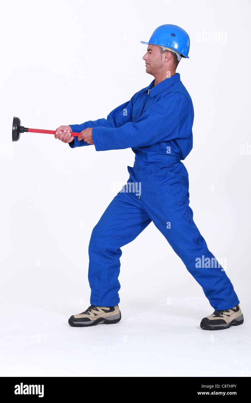Worker with a plunger Stock Photo - Alamy