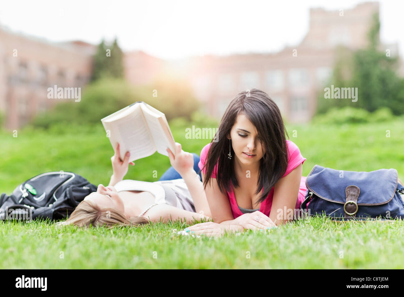USA, Washington, Seattle, Two female college student lying on grass ...