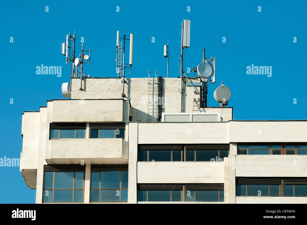 GSM transmitters on a roof of white administrative building Stock Photo ...