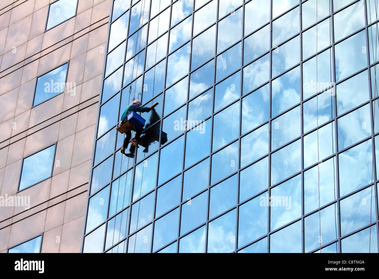 window cleaner hanging on rope at work on skyscraper Stock Photo - Alamy