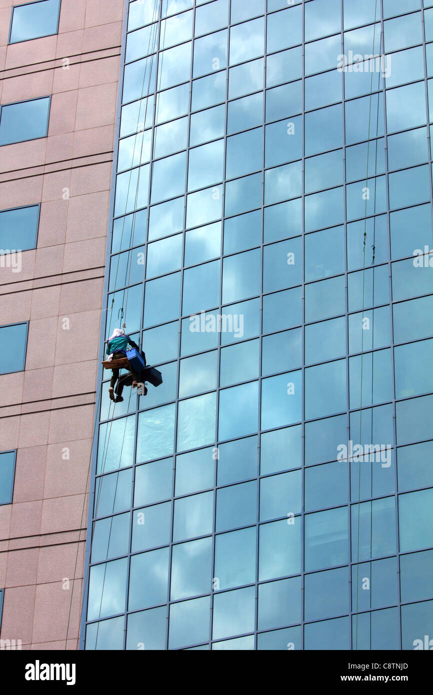 window cleaner hanging on rope at work on skyscraper Stock Photo - Alamy