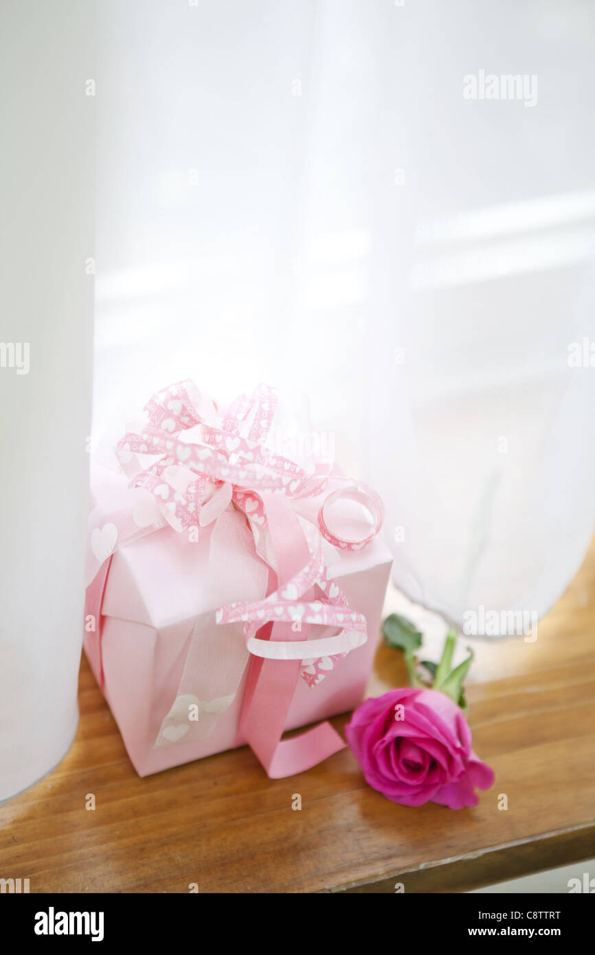Wrapped Pink Gift Box And Pink Rose Stock Photo - Alamy