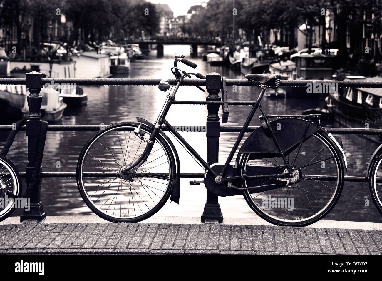 Typical male Dutch bicycle locked on a canal railing in Amsterdam Stock ...