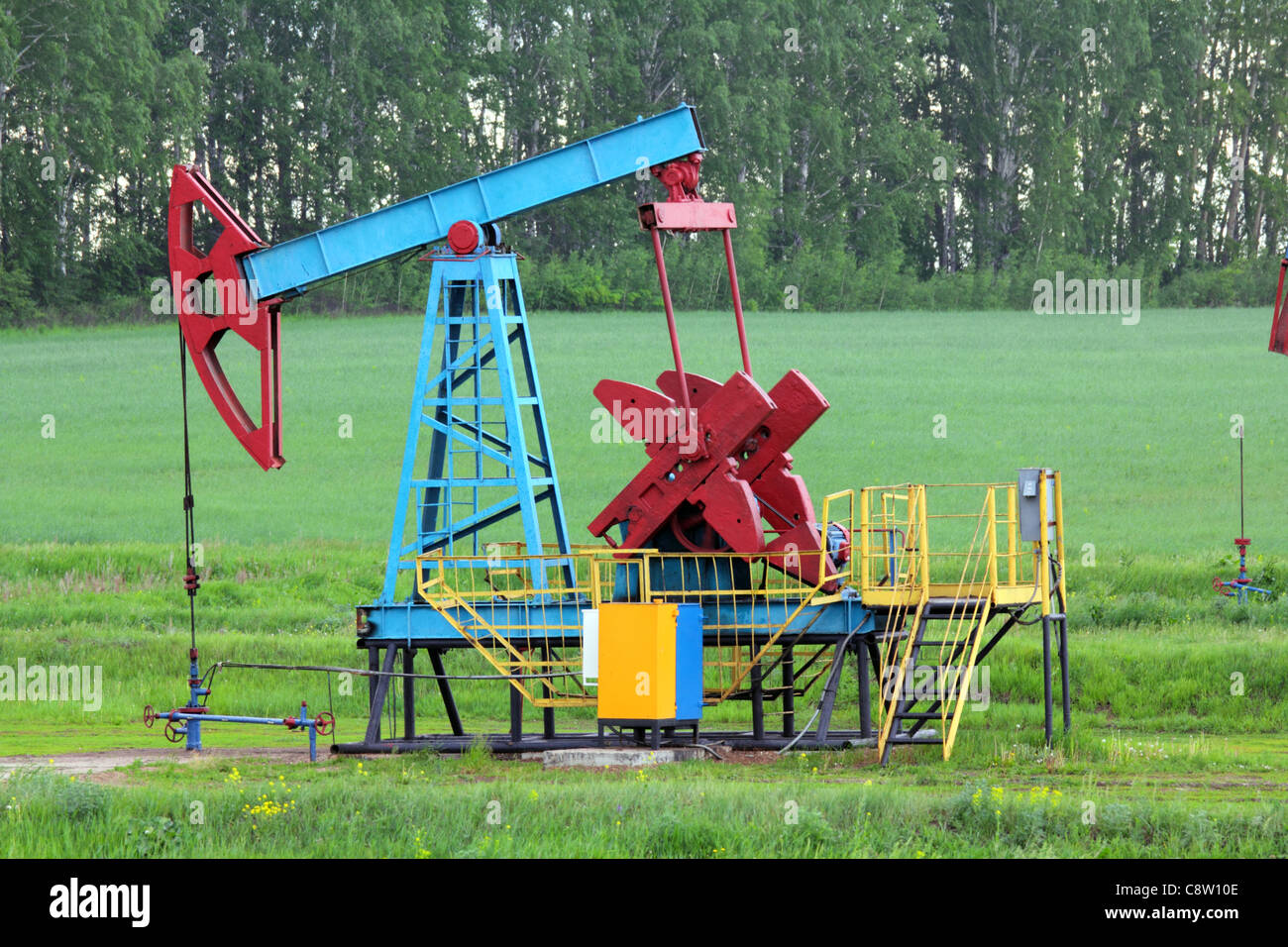 working old oil pump in green field Stock Photo - Alamy