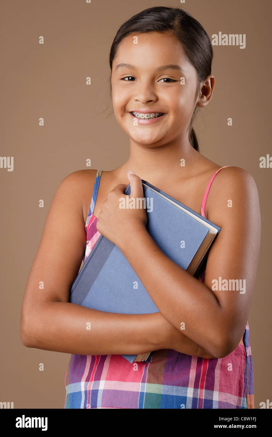 Studio portrait of girl holding book Stock Photo - Alamy