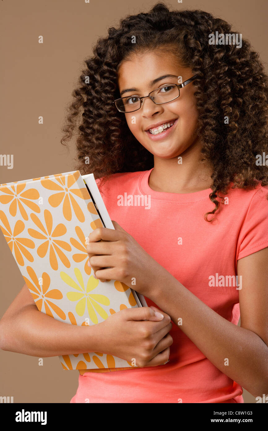 Studio portrait of girl holding book Stock Photo - Alamy