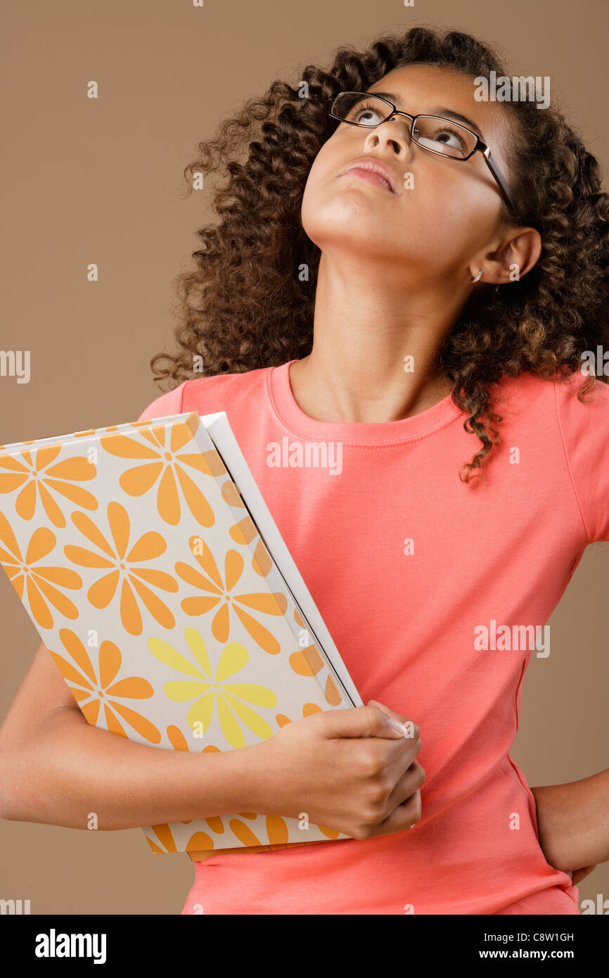 Studio portrait of girl holding book Stock Photo - Alamy