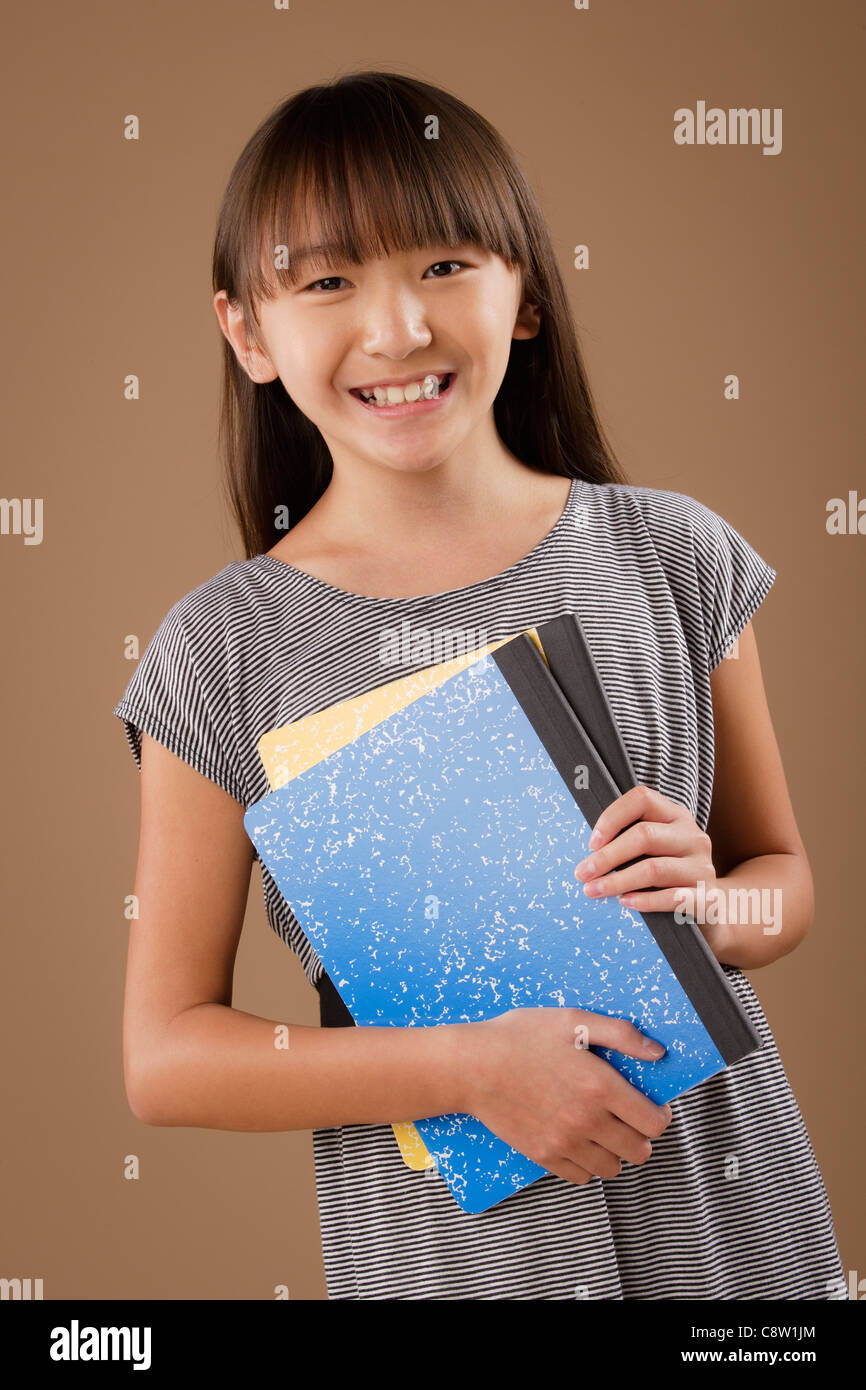 Studio portrait of girl holding book Stock Photo - Alamy