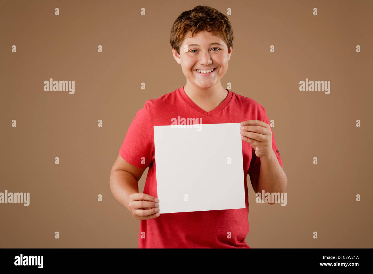 Studio portrait of boy holding blank sheet of paper Stock Photo - Alamy