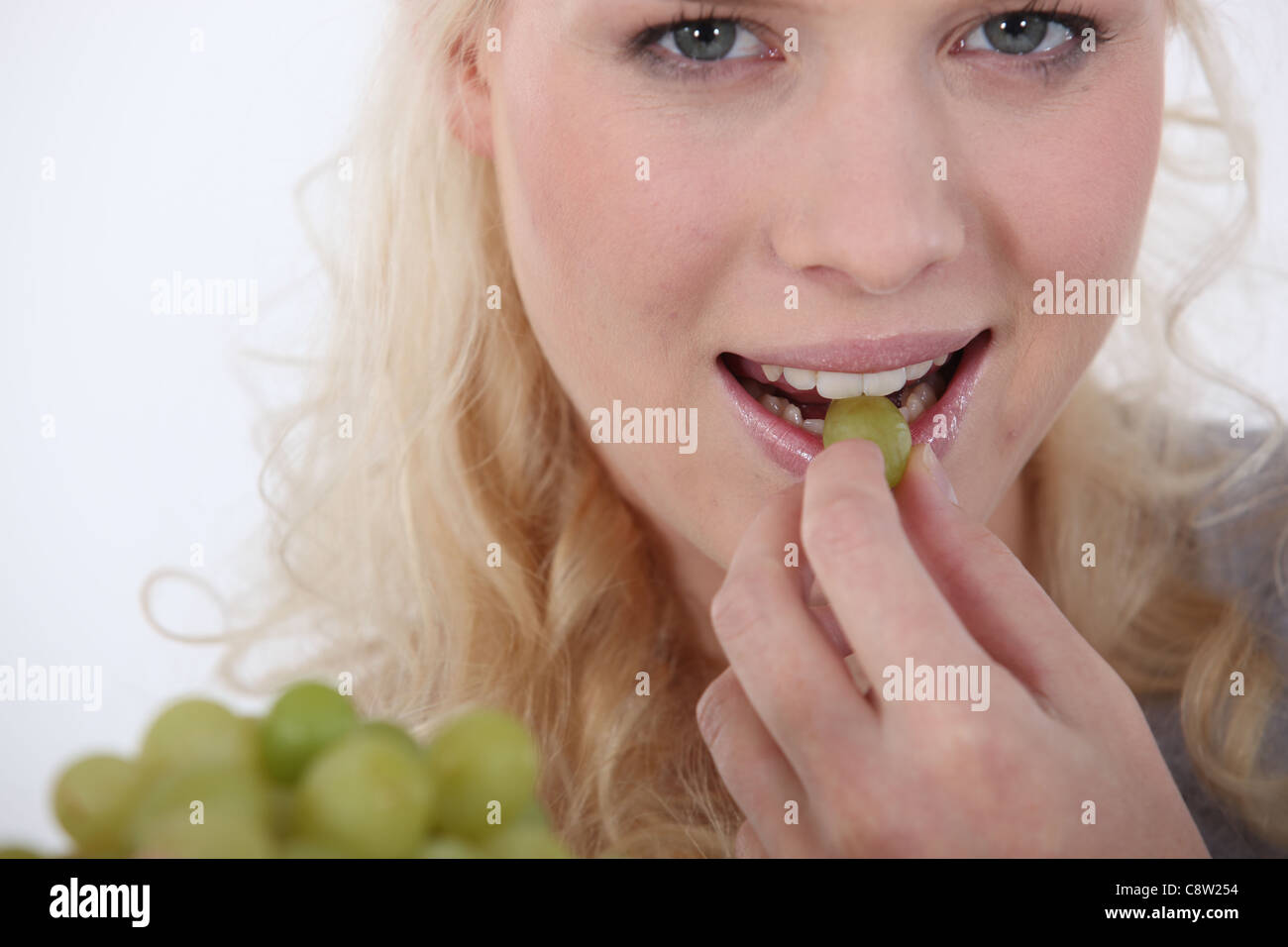 Woman eating green grapes Stock Photo - Alamy
