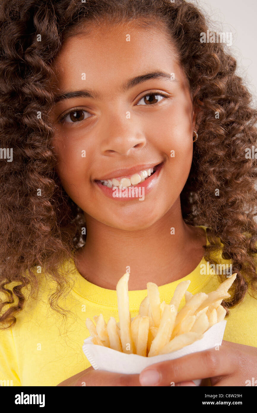 Studio portrait of girl holding french fries Stock Photo - Alamy