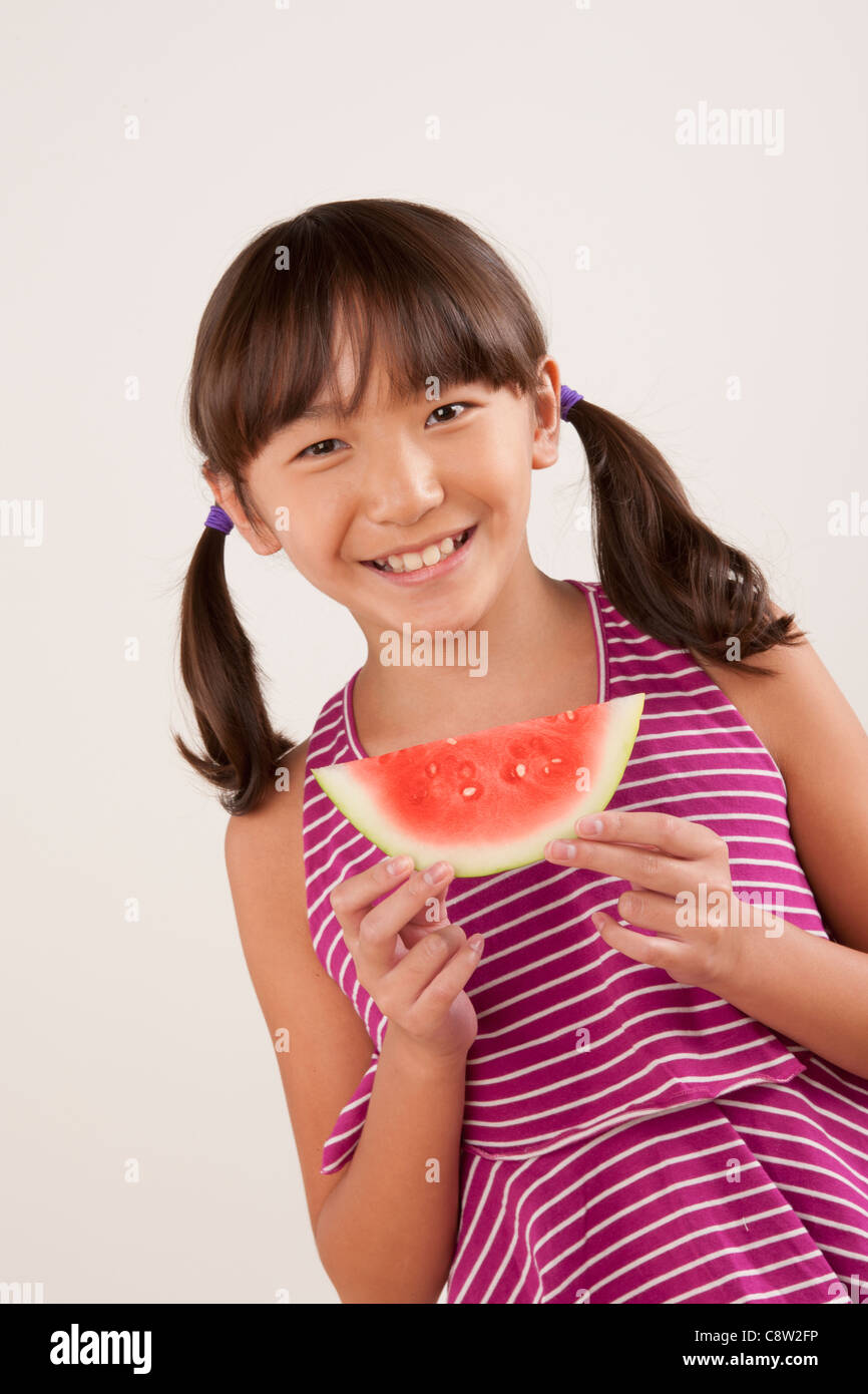 Studio portrait of girl eating watermelon Stock Photo - Alamy