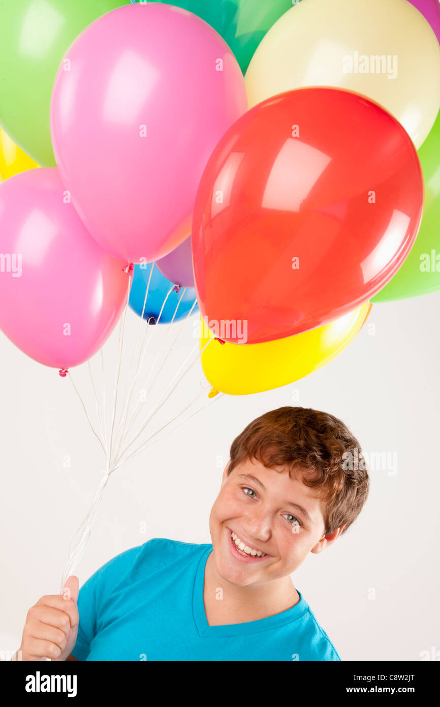 Portrait of smiling boy holding balloons, studio shot Stock Photo - Alamy