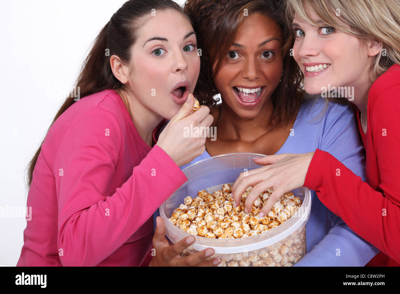 Friends eating caramel popcorn together Stock Photo - Alamy