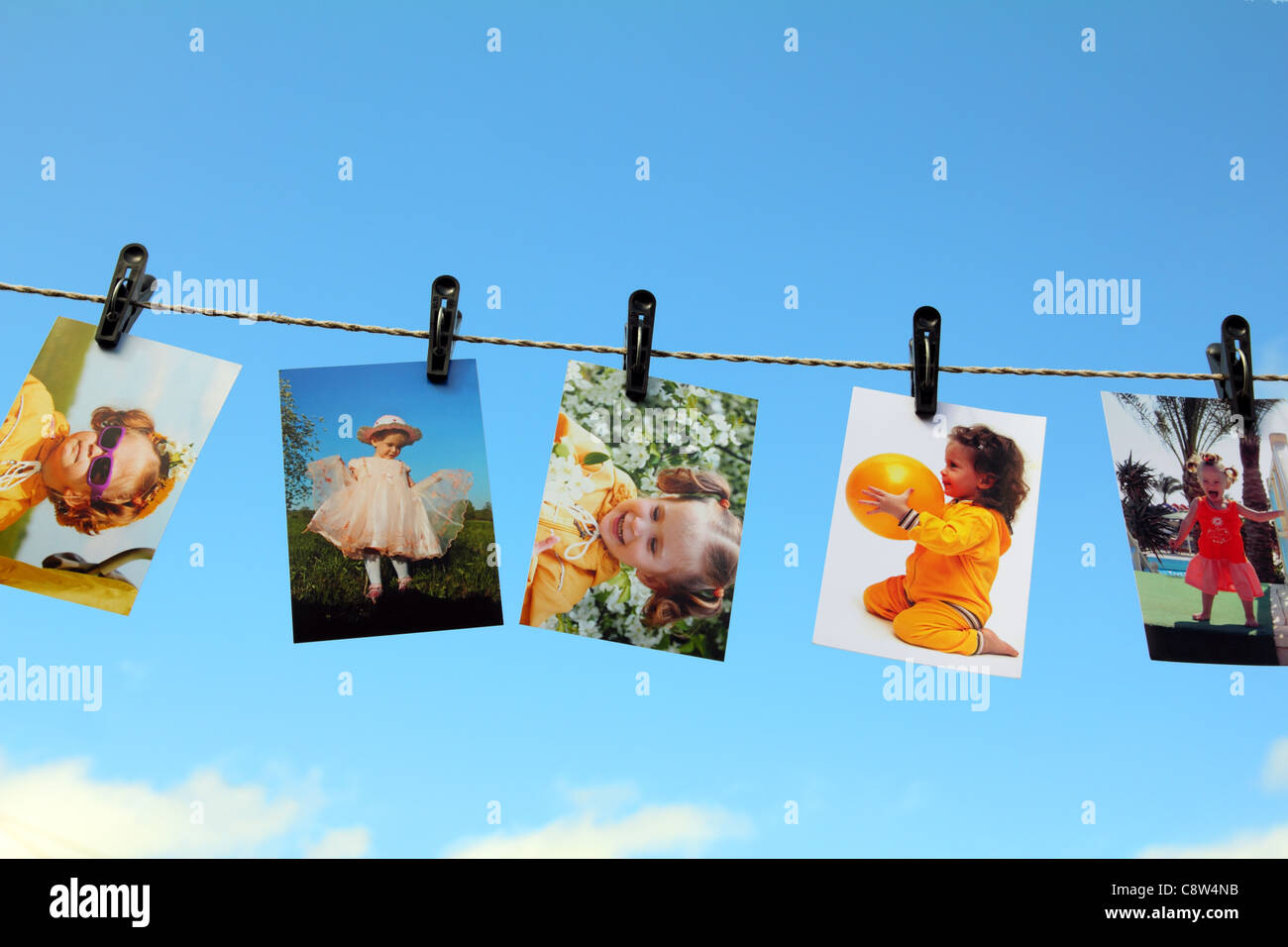 photos are hanging against blue sky with clouds Stock Photo - Alamy