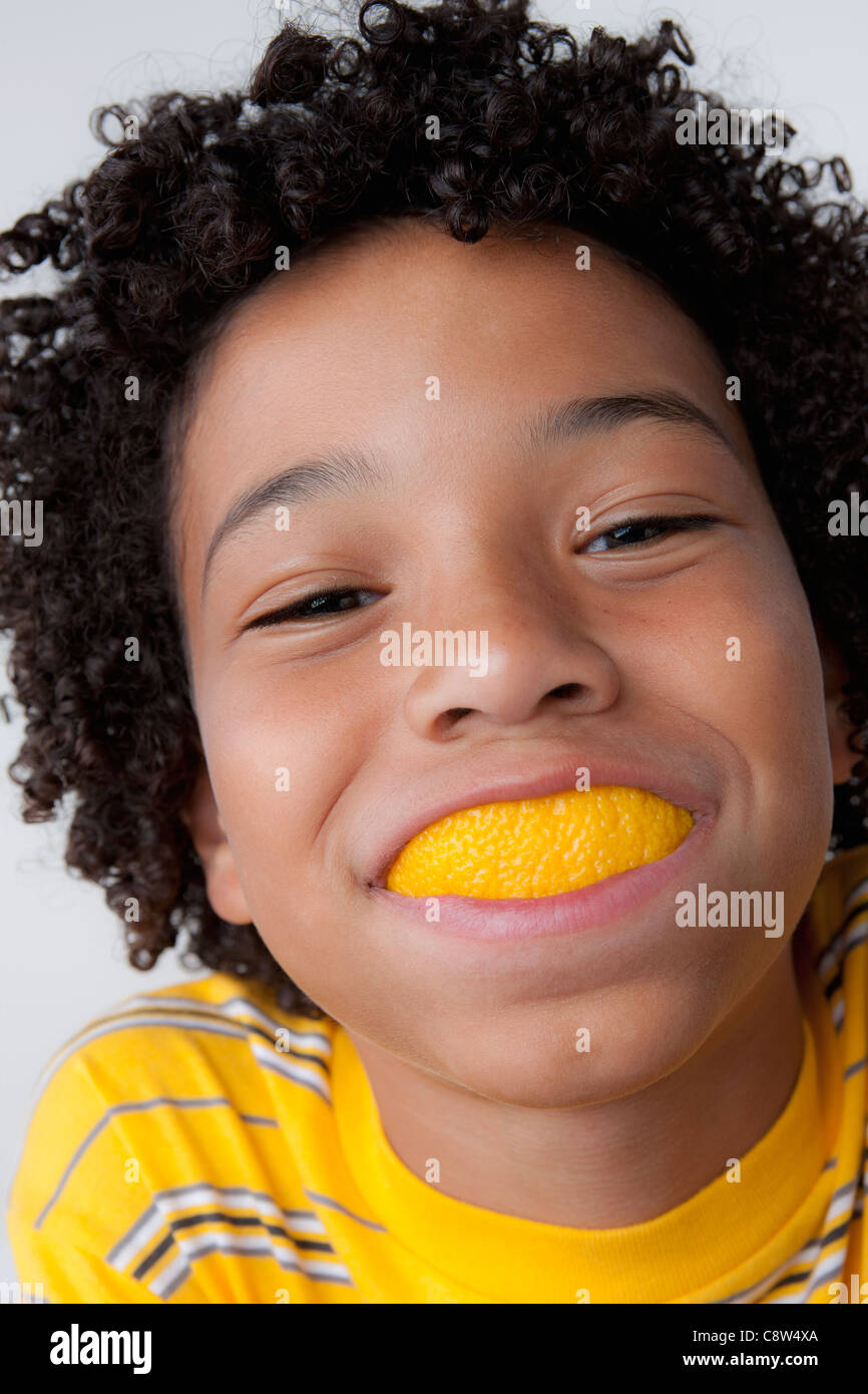 Studio portrait of boy with slice of lemon in mouth Stock Photo - Alamy