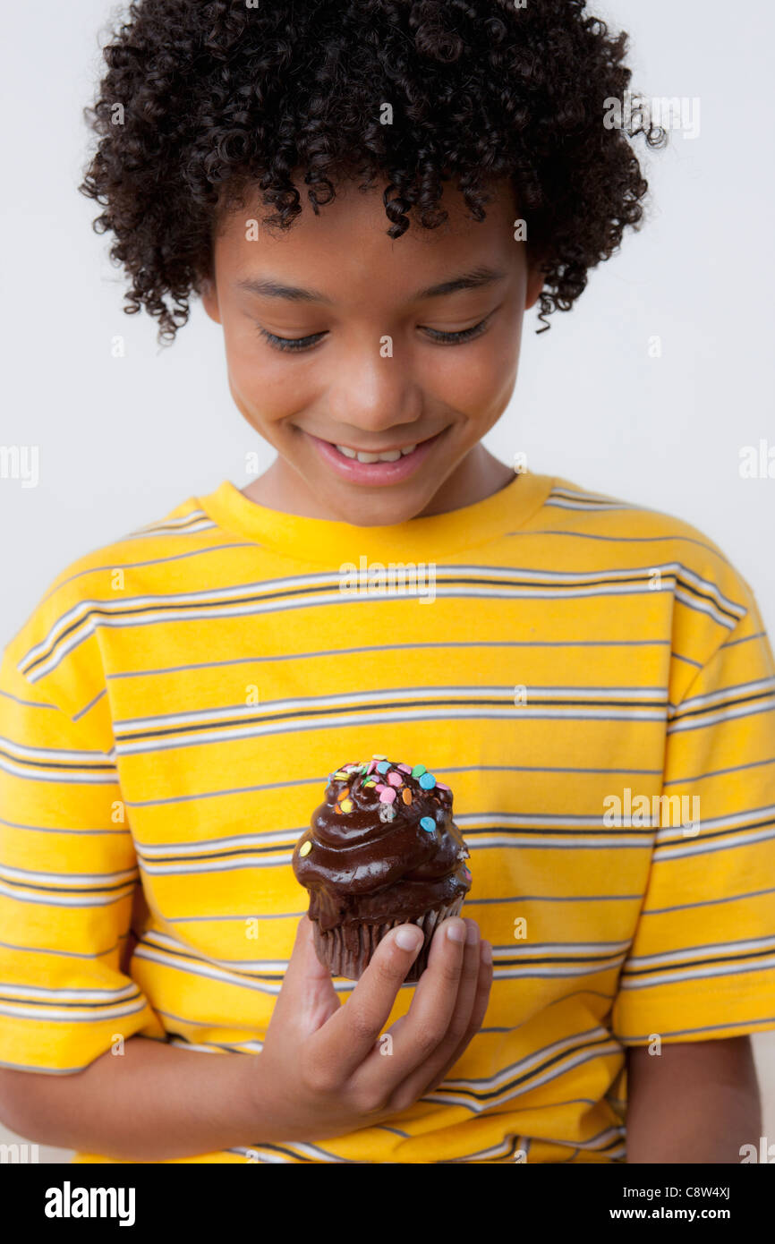 Studio portrait of boy holding muffin Stock Photo - Alamy