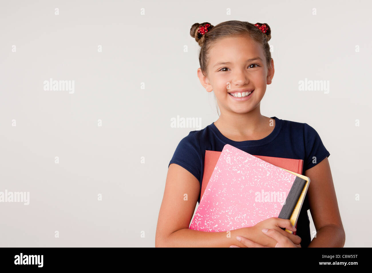 Studio portrait of girl holding books Stock Photo - Alamy