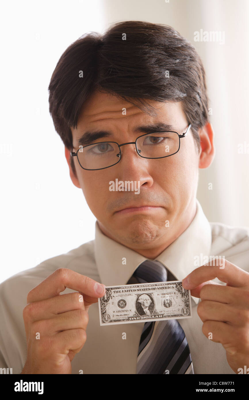 Sad business man holding one dollar note Stock Photo - Alamy