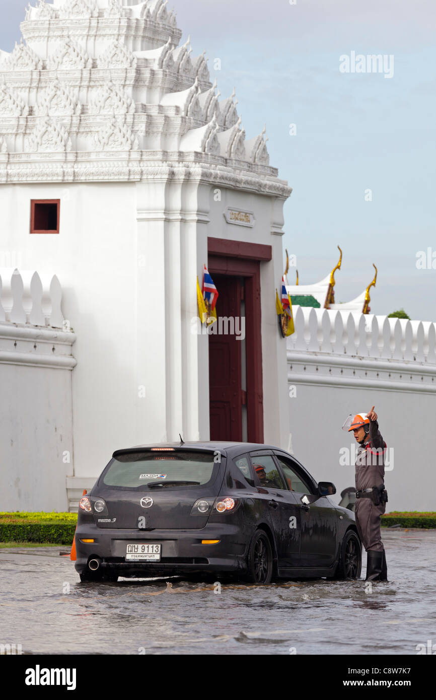 Police directing traffic through flood water near the Grand Palace in ...