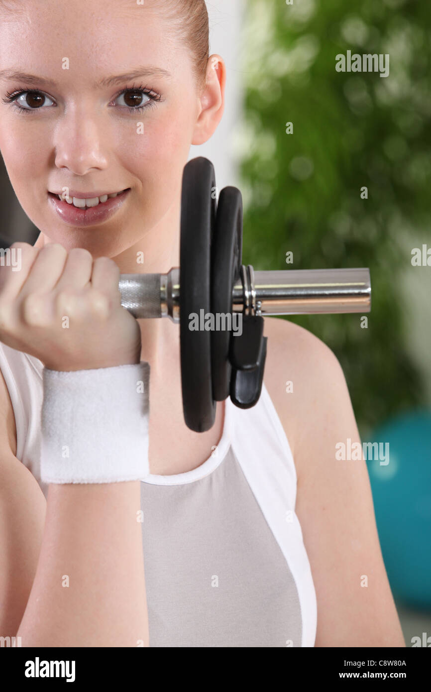 Young woman using a barbell Stock Photo - Alamy