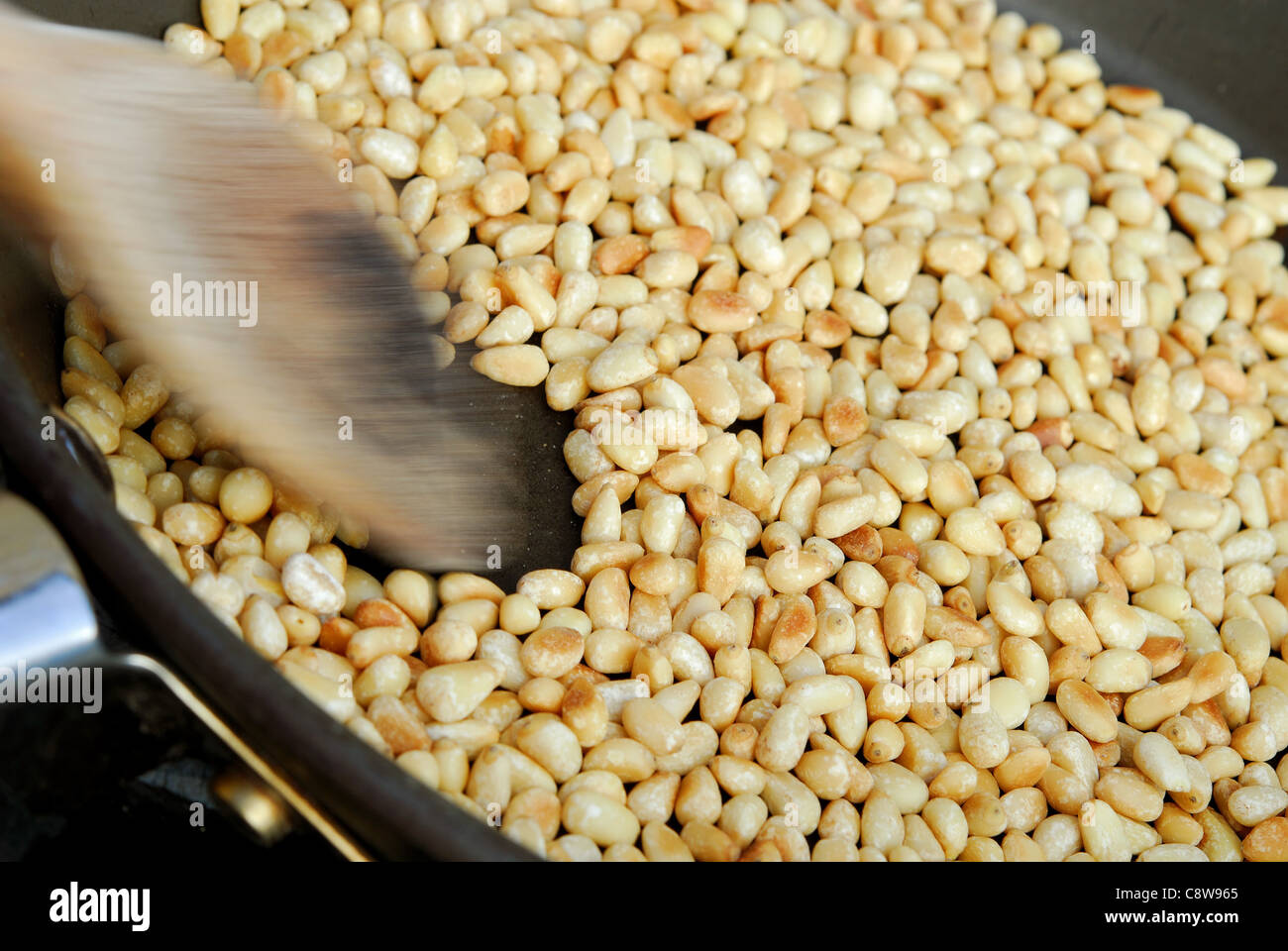 Pine nut kernels being toasted to enhance their flavour before being ...