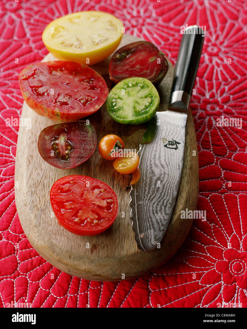 Various juicy sliced tomatoes on cutting board with knife Stock Photo ...
