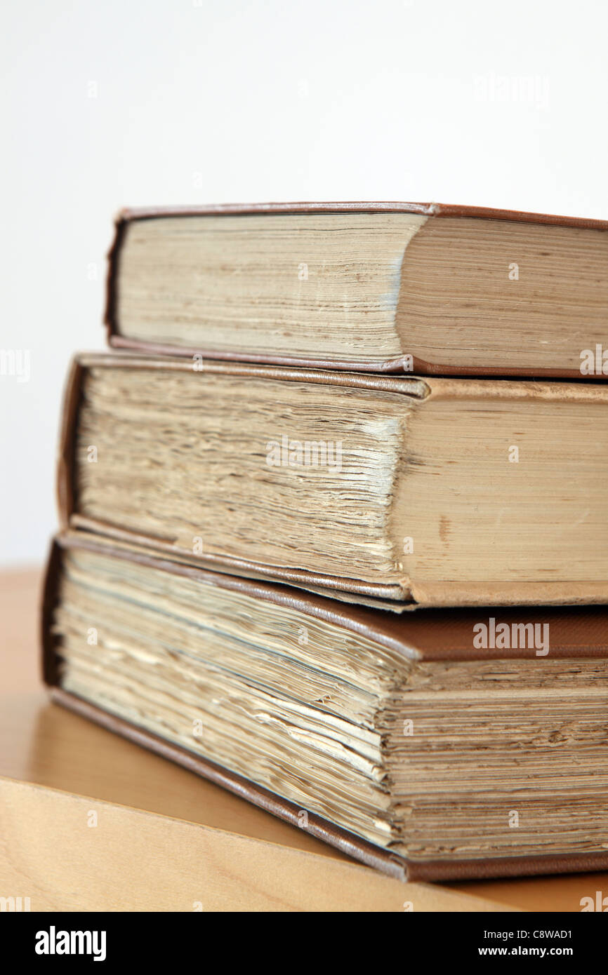 vertical stack of three old hard cover books on a wooden surface ... vertical stack of three old hard cover books on a wooden surface ...