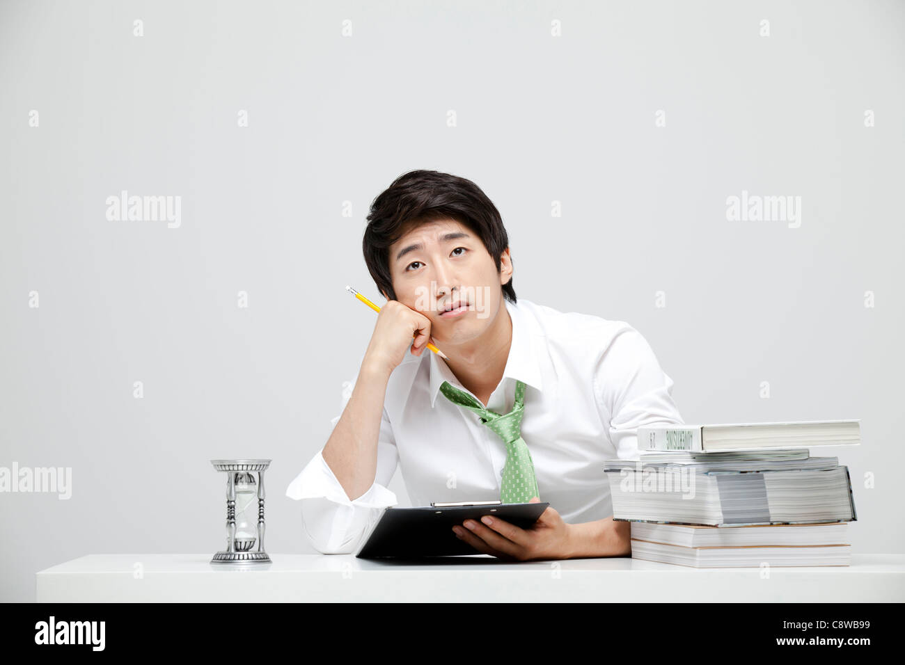 Asian Businessman Getting Bored At Work Stock Photo - Alamy
