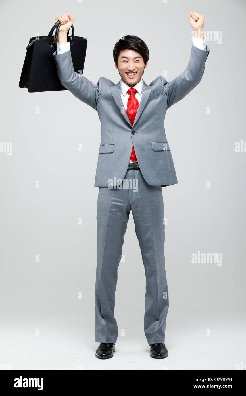 Asian Businessman Clenching His Fist And Carrying Briefcase Stock Photo ...