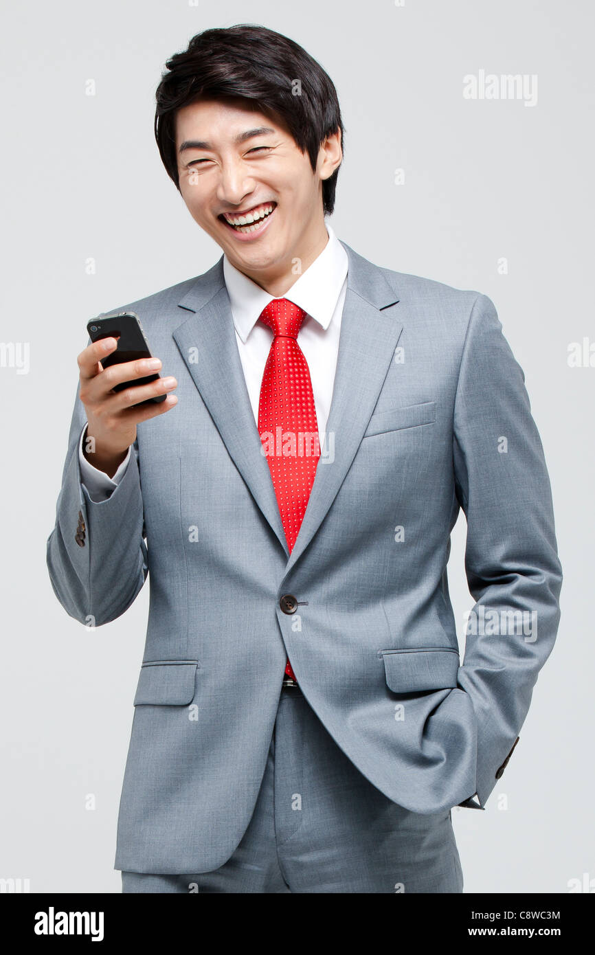 Laughing Asian Businessman Using Cell Phone Stock Photo - Alamy