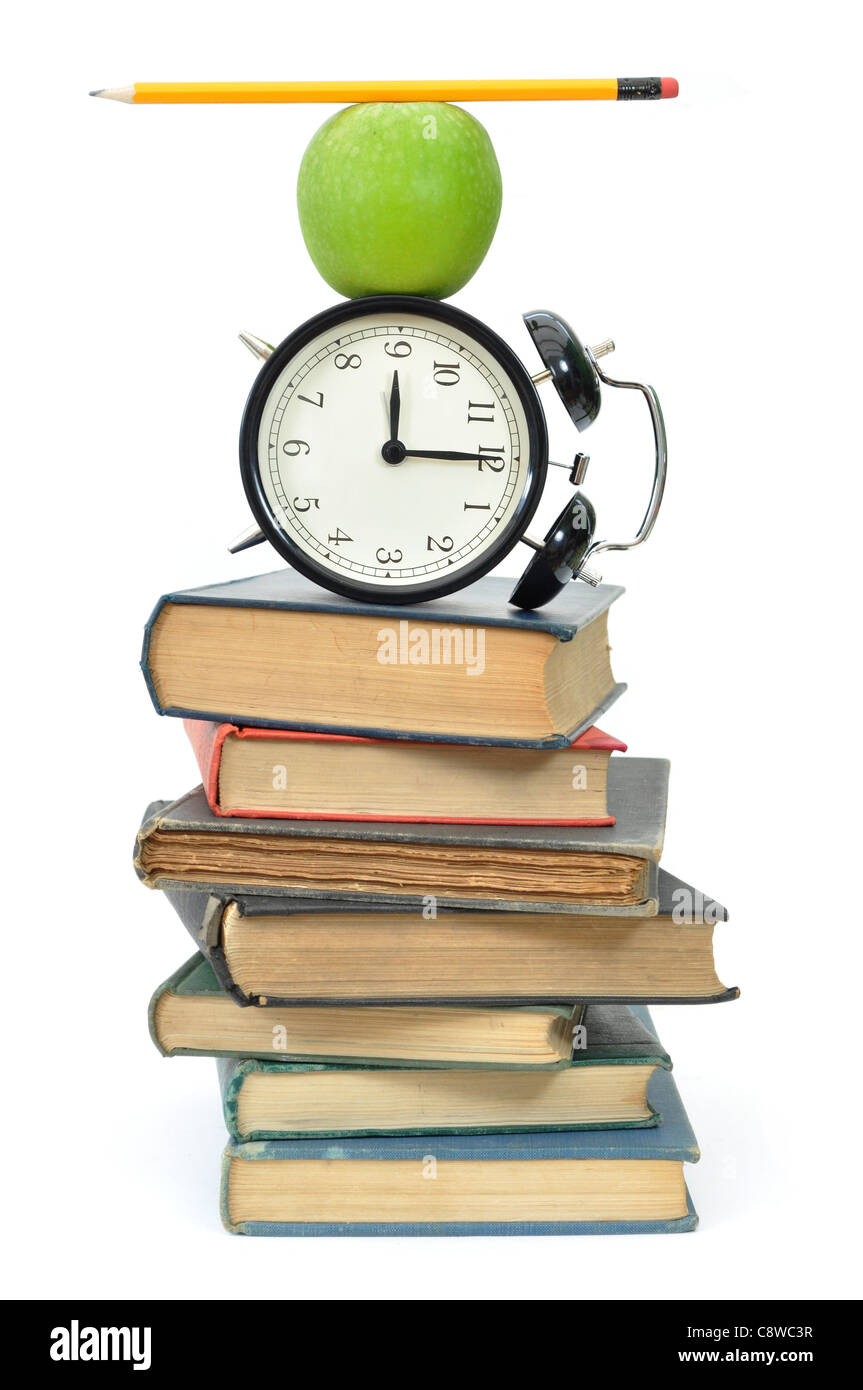 Balancing act of objects, including an apple and closk, on top of a ...