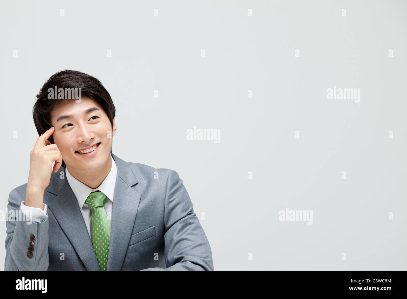 Portrait Of Smiling Asian Businessman Thinking Stock Photo - Alamy