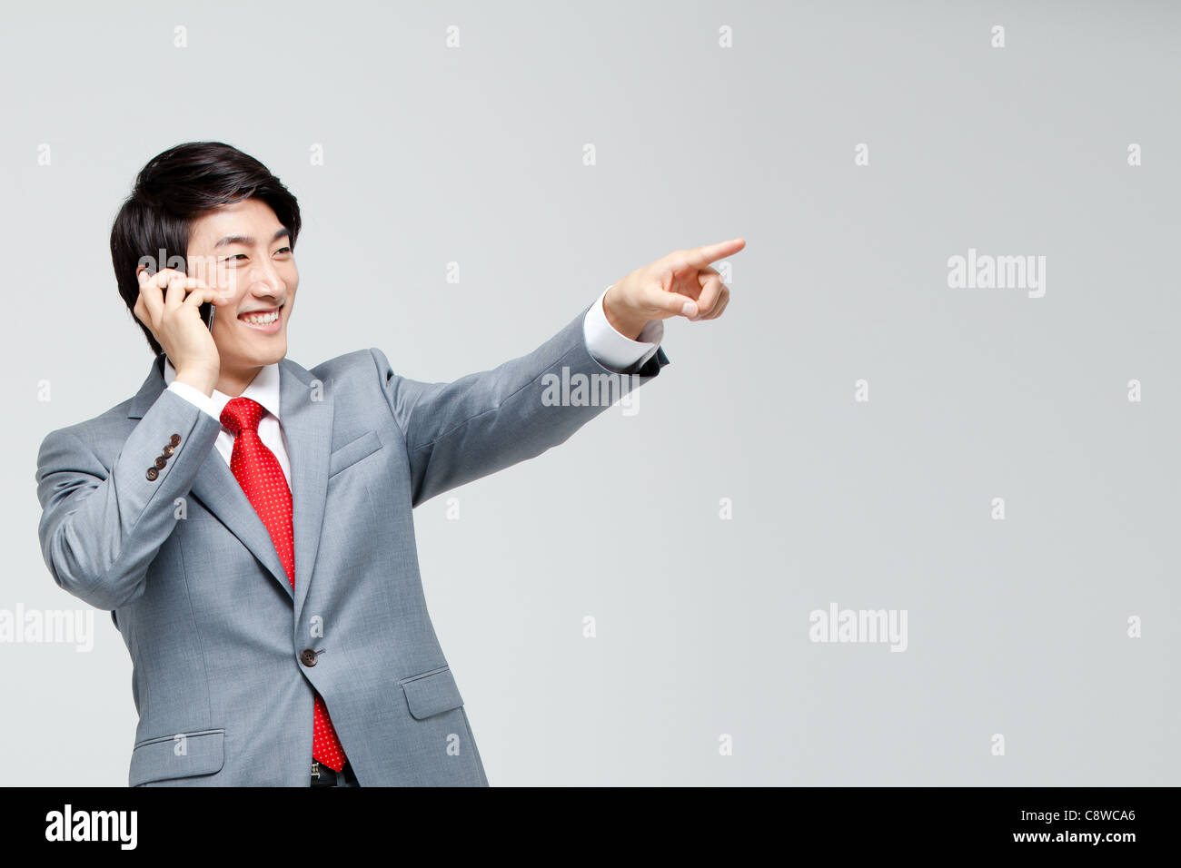 Asian Businessman Using Cell Phone And Pointing Finger Stock Photo - Alamy