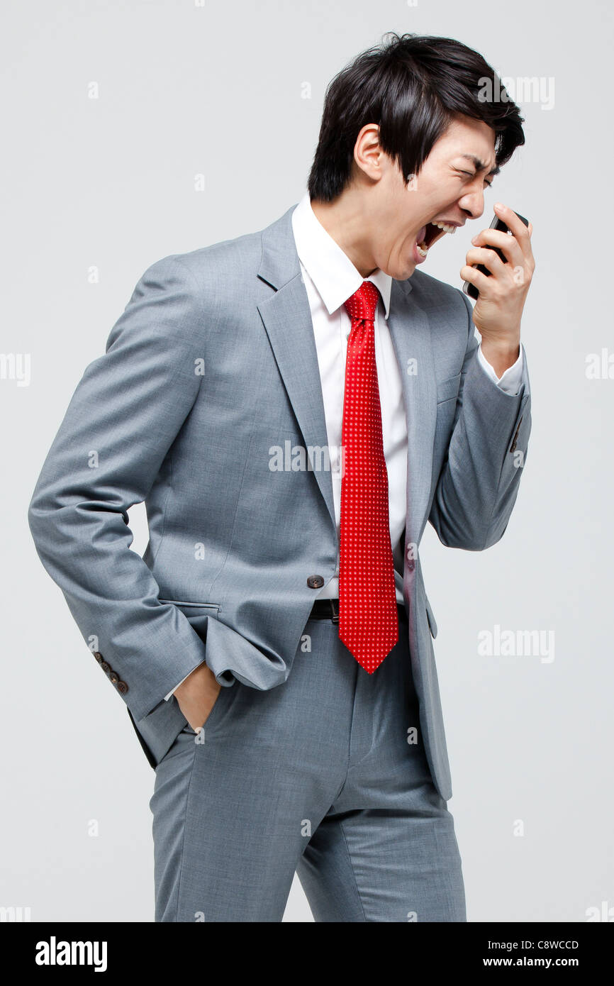 Asian Businessman Shouting Into Cell Phone Stock Photo - Alamy
