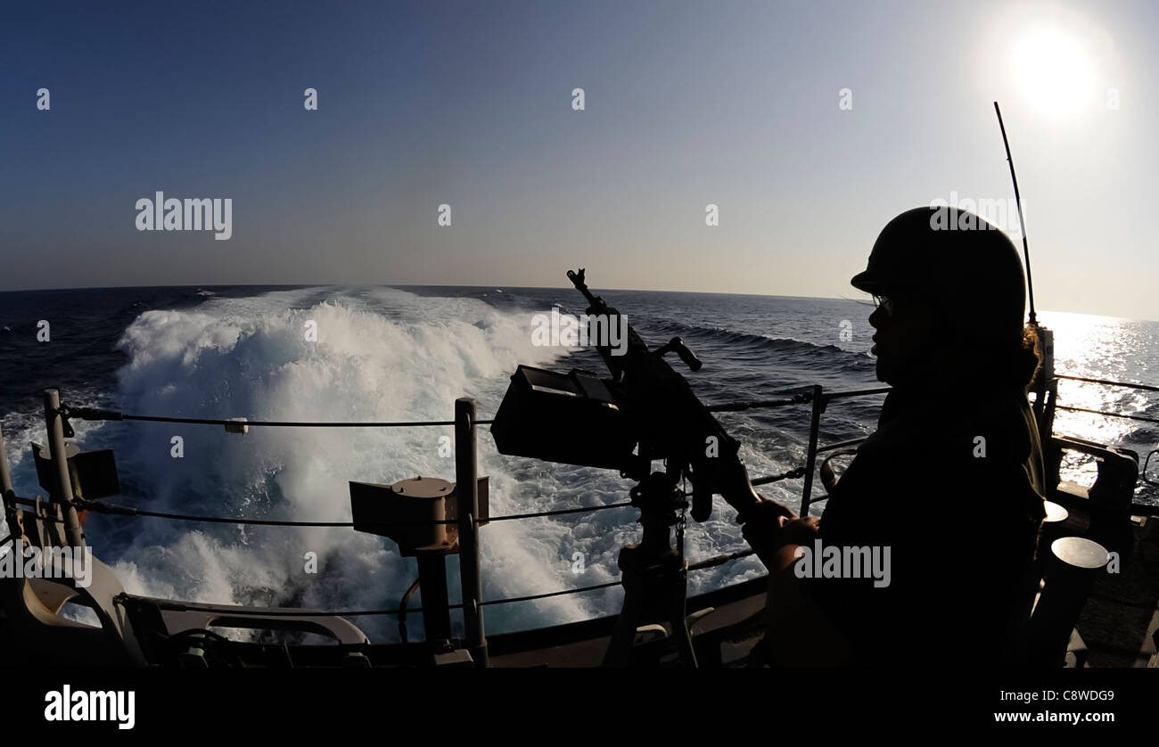 a .50-caliber machine gun on the fantail of the guided-missile cruiser ...