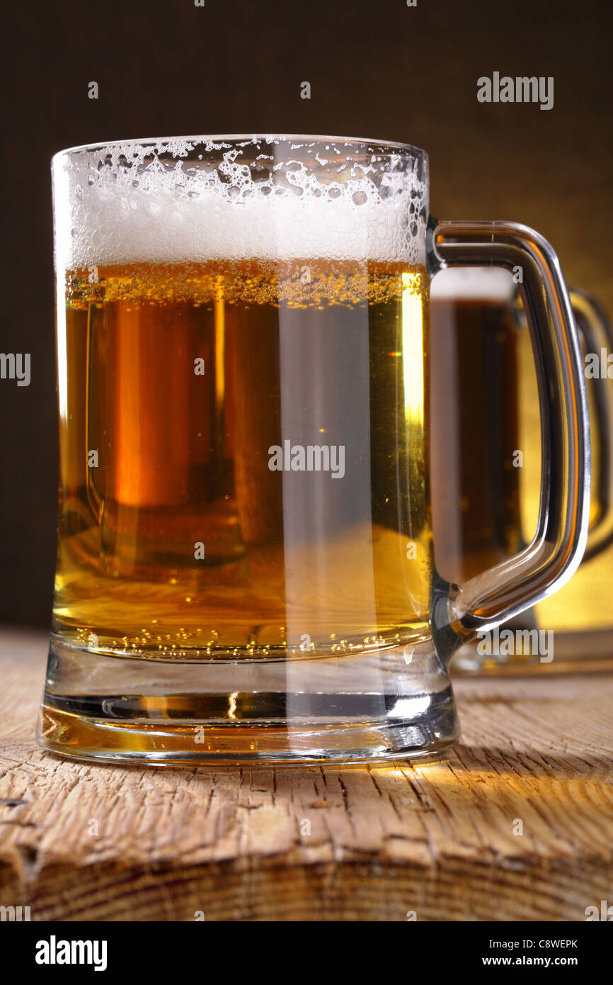 Mug of beer close-up on the wood table Stock Photo - Alamy