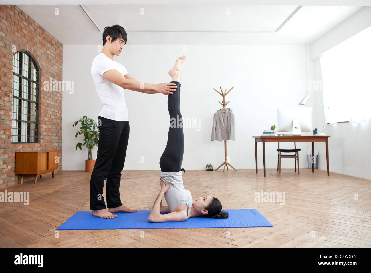 Male Instructor Helping Woman With Pose Stock Photo - Alamy