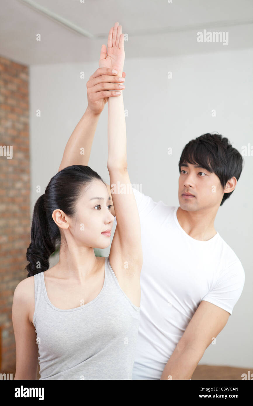 Male Instructor Helping Woman With Pose Stock Photo - Alamy