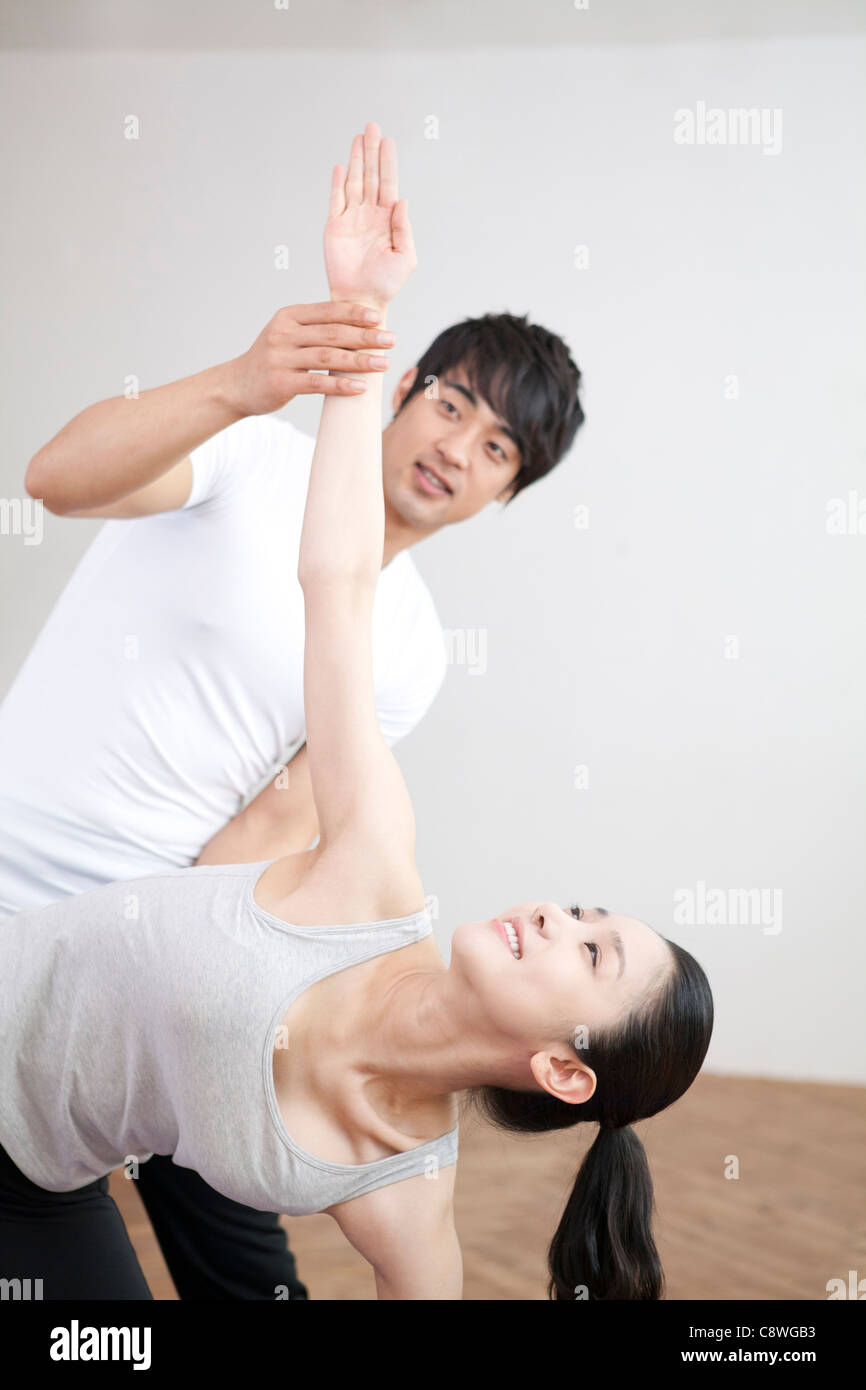 Male Instructor Helping Woman With Pose Stock Photo - Alamy