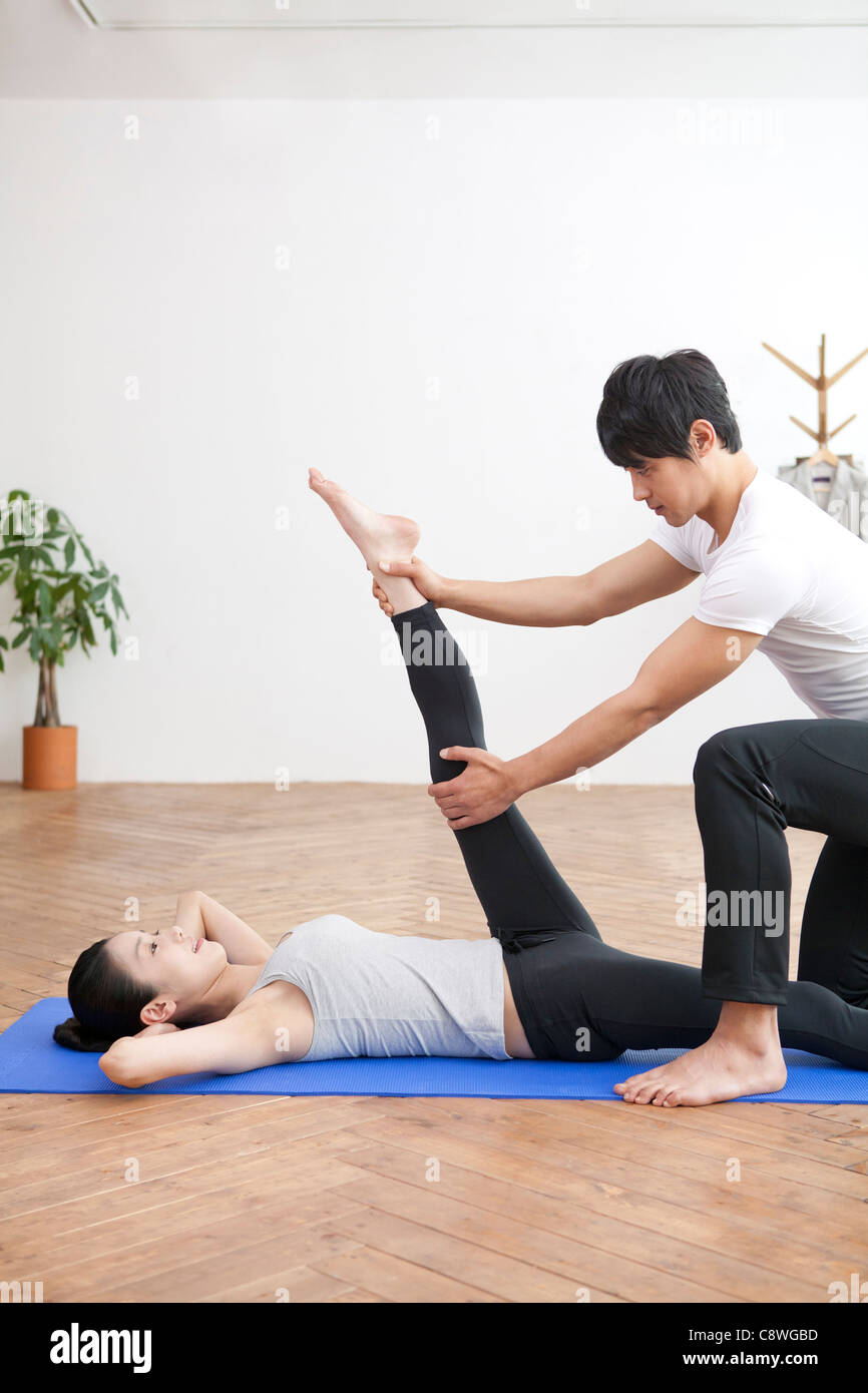 Male Instructor Helping Woman With Pose Stock Photo - Alamy