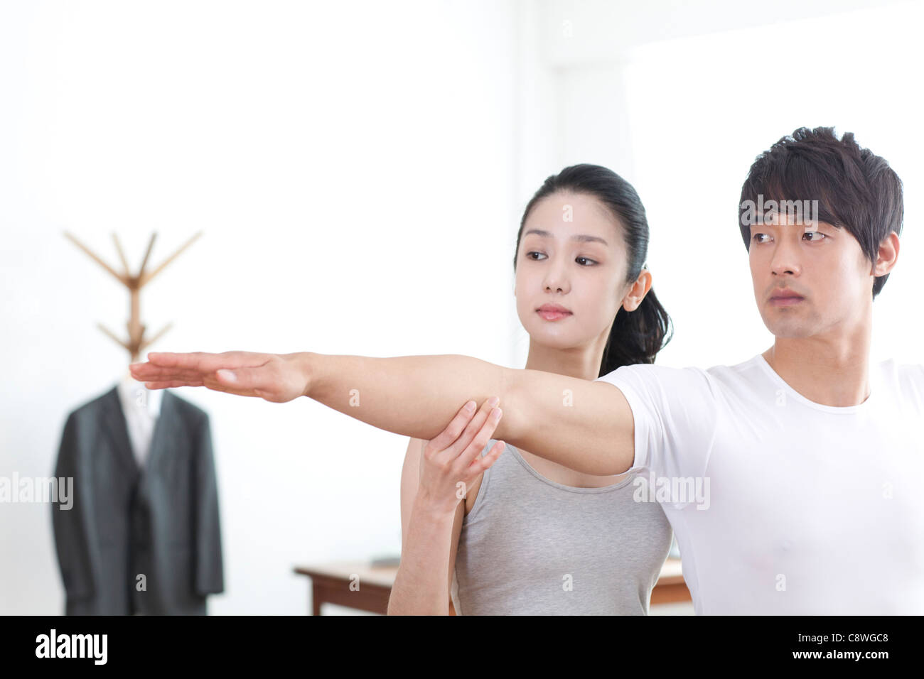 Female Instructor Helping Woman With Pose Stock Photo - Alamy