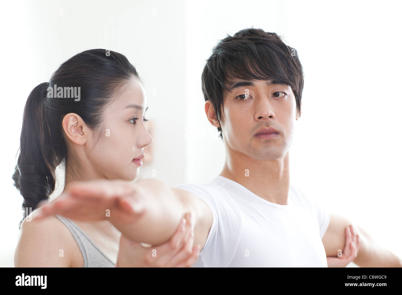 Female Instructor Helping Woman With Pose Stock Photo - Alamy