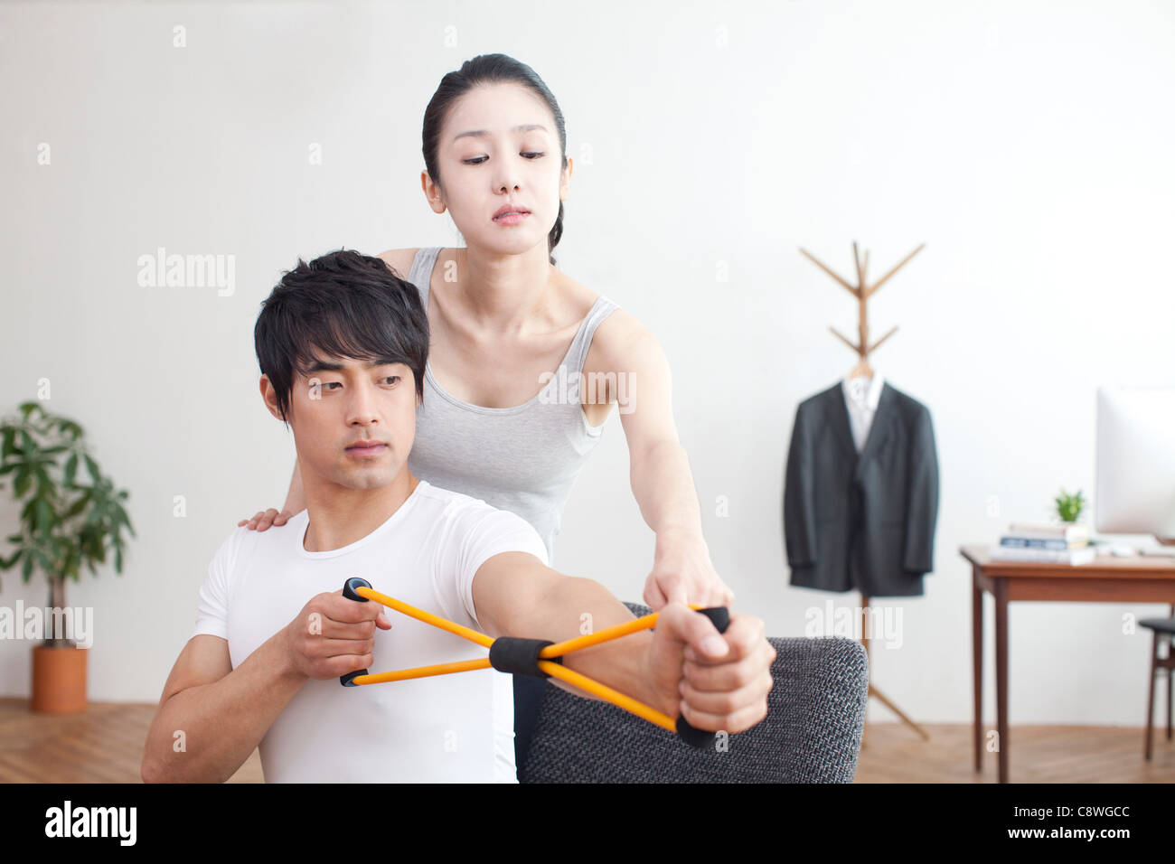 Female Instructor Helping Woman With Pose Stock Photo - Alamy