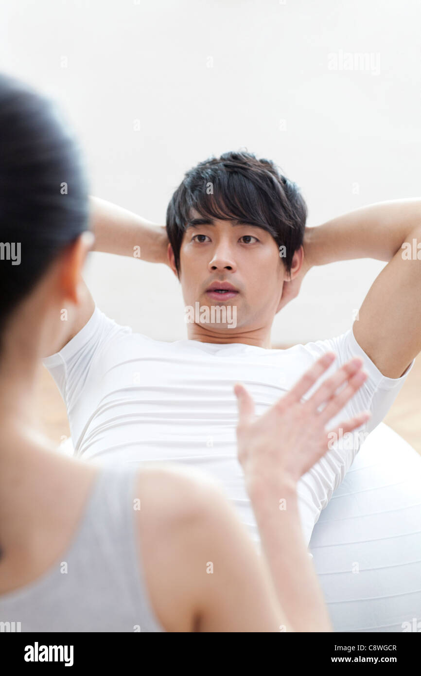 Female Instructor Helping Woman With Pose Stock Photo - Alamy