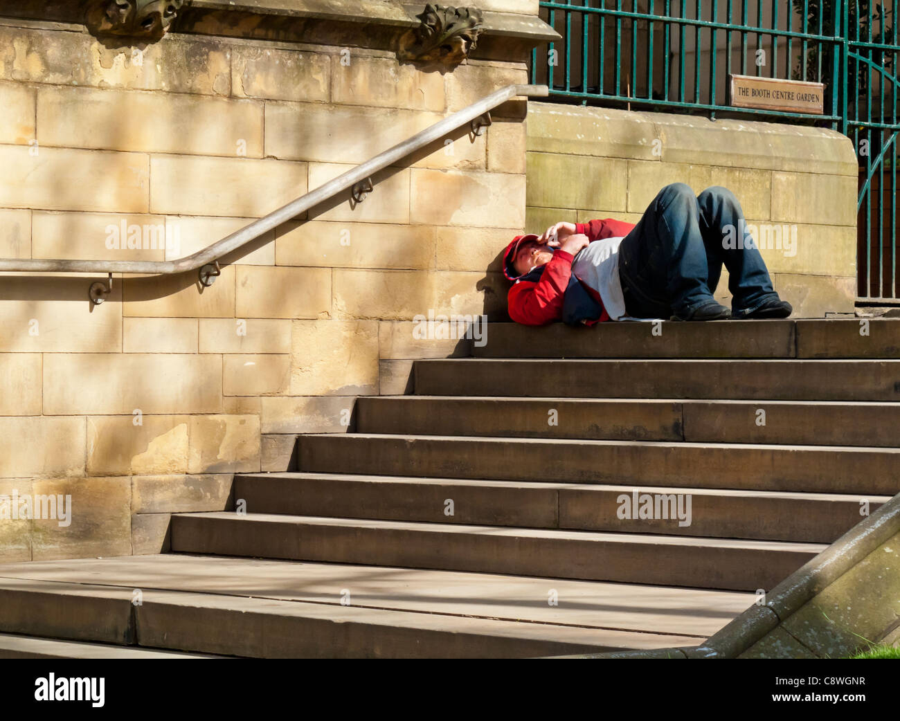 Homeless man lying on the steps of Manchester Cathedral in Manchester ...