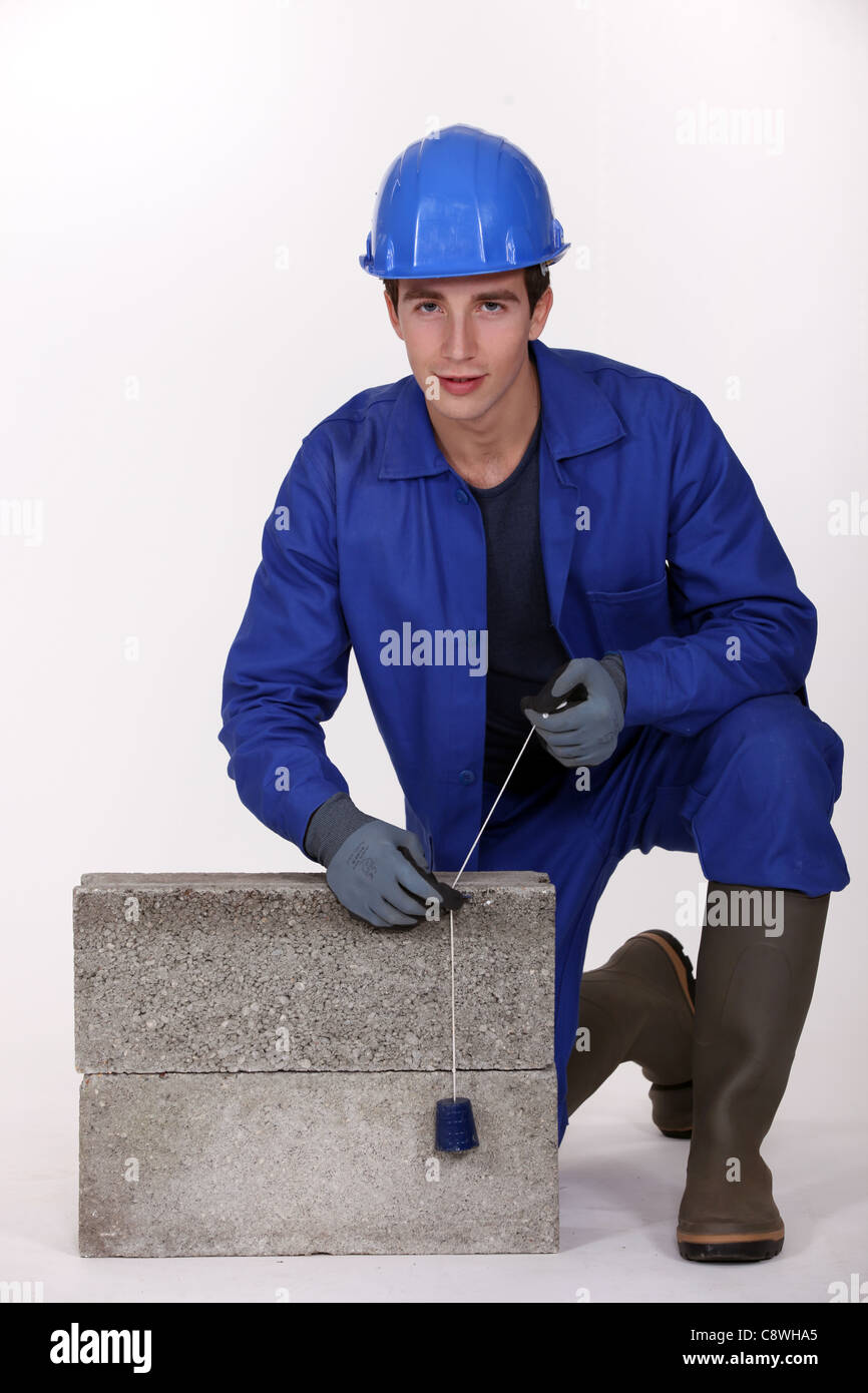 Bricklayer in blue overalls Stock Photo - Alamy